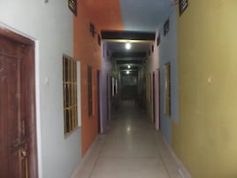 Um corredor com portas de ambos os lados, dando acesso a quartos.