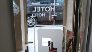 Entrada de hotel com placa indicando quarto silencioso e área de estacionamento.