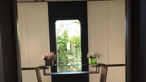 Interior moderno com uma mesa de vidro, um banco e um cão deitado no chão.
