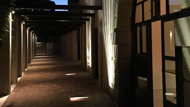Um corredor com teto abobadado, amplas janelas e uma galeria coberta.