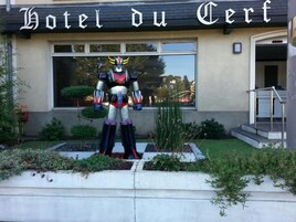 Hotel chamado 'Hotel du Cert' com uma grande escultura de metal em frente.