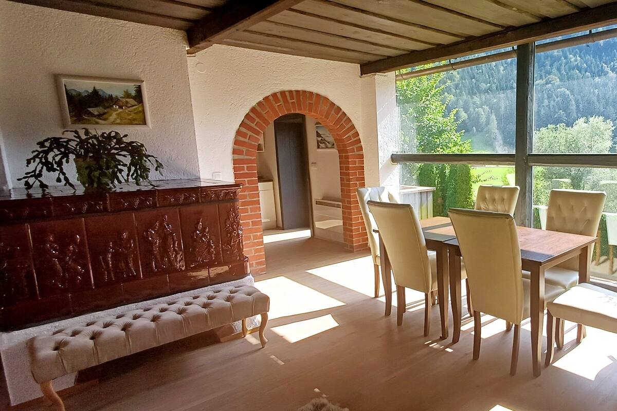 Uma área de refeições com um arco de tijolos, um banco e uma mesa com cadeiras.