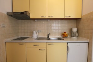 Apartamento standard, 1 quarto, no piso térreo | Cozinha privada | Geladeira, micro-ondas, cooktop, cafeteira/chaleira