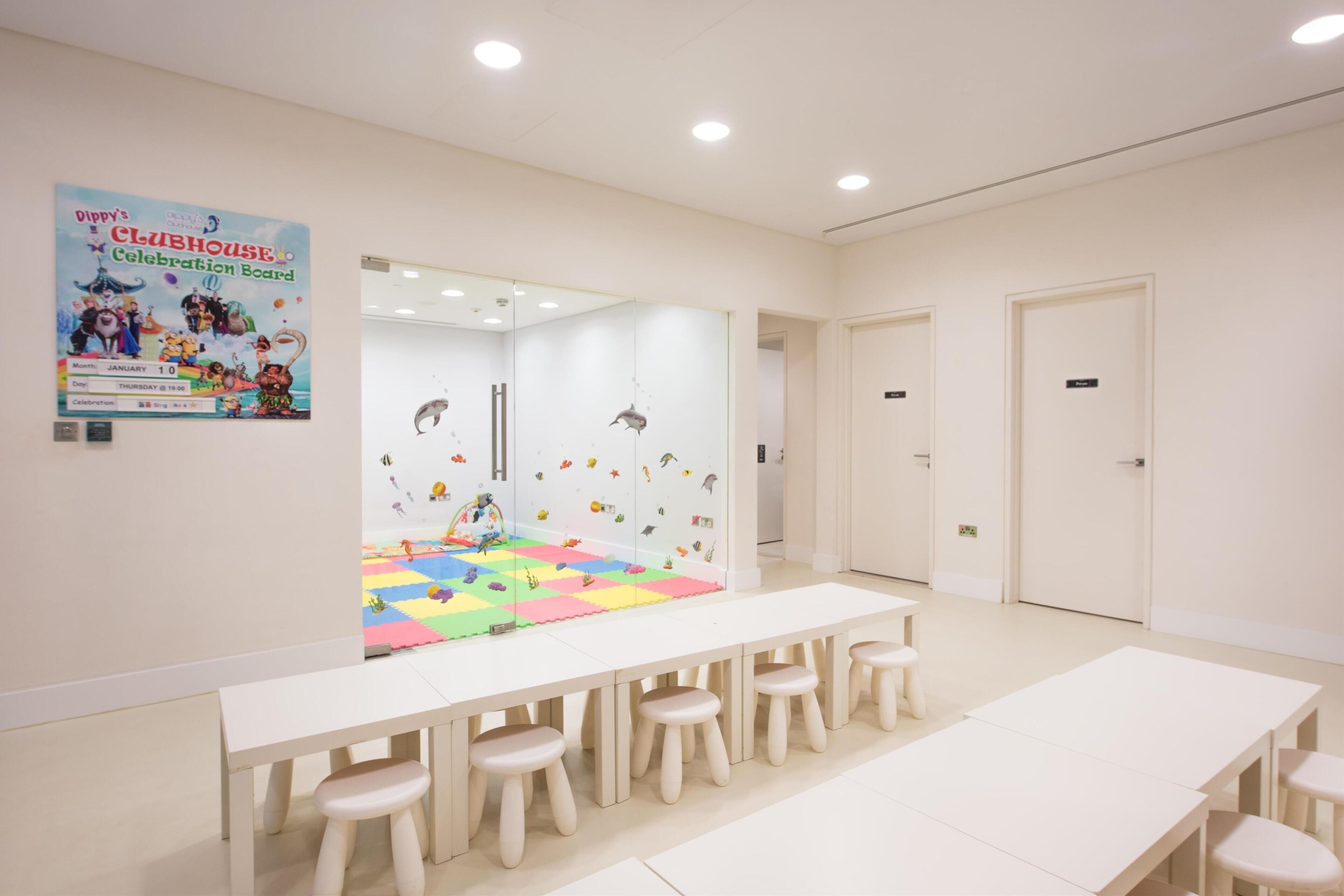 Uma sala de conferência com uma mesa comprida, várias cadeiras e um tapete colorido no centro.