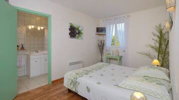 Quarto com cama, luminária de cabeceira e janela com cortinas.