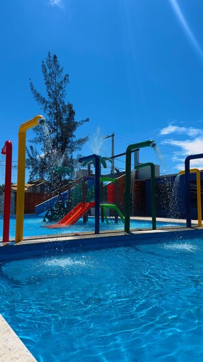 Uma piscina com recursos aquáticos e escorregadores.