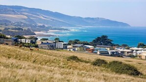 Uma área residencial costeira com casas numa encosta com vista para o oceano.