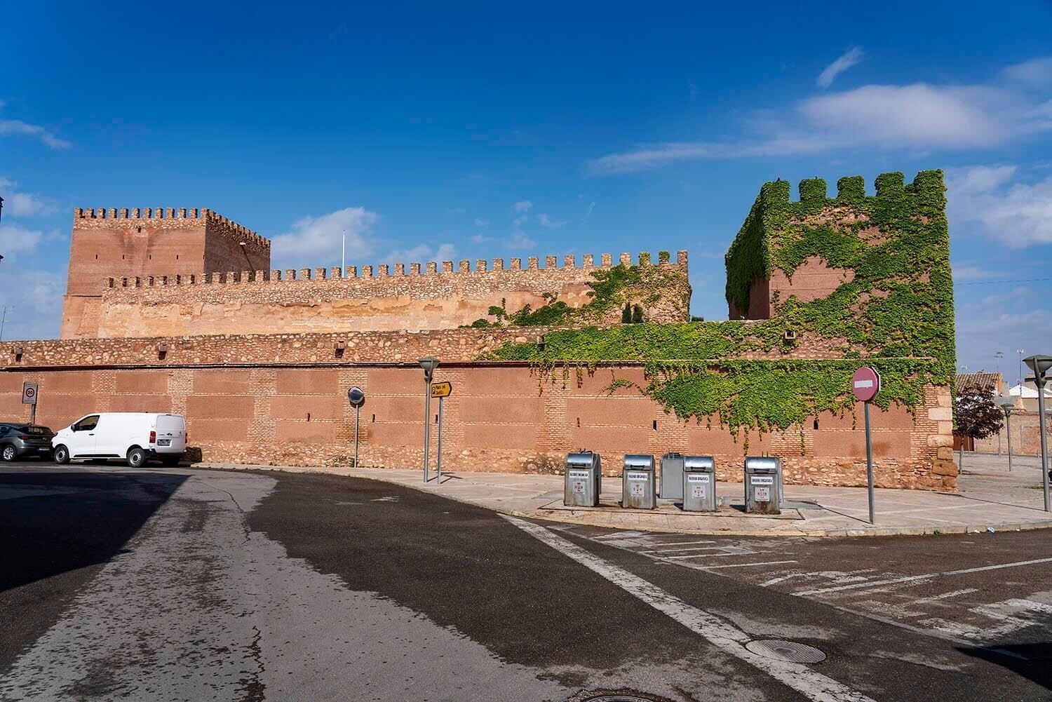 Mural de pedra histórica com uma carrinha branca estacionada em frente.