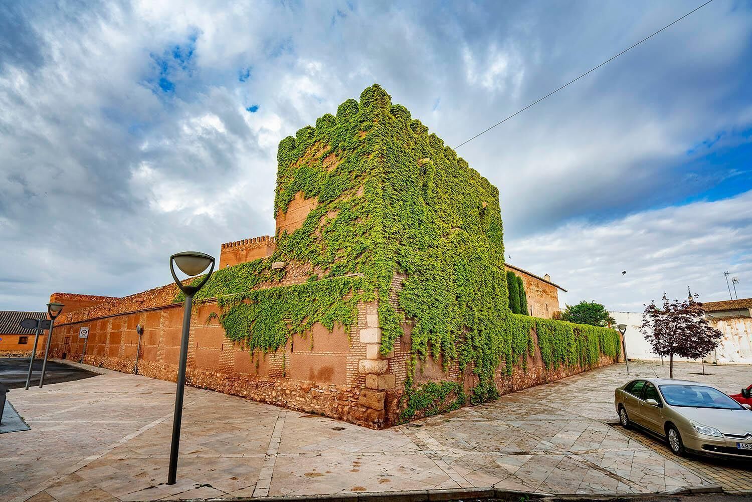Um edifício com fachada de tijolos parcialmente coberta por hera.