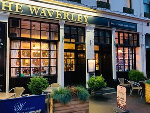 Exterior do Hotel Waverley, com lounge de bar e placa indicando jardim de cerveja.