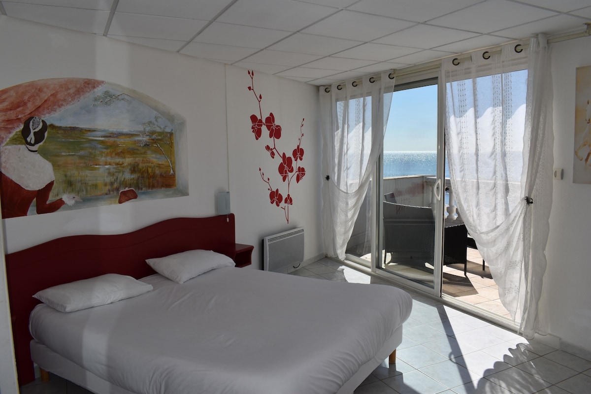 Quarto com cama, radiador, janela com cortinas e vista para o exterior.