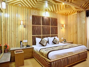 Quarto com decoração em madeira, uma cama grande, mesas de cabeceira e uma cabeceira estampada.