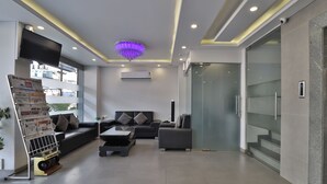 Um lobby moderno de hotel com sofá, mesa de centro e suporte para revistas.