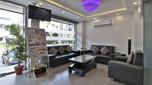 Uma sala de estar moderna com sofá, mesa de centro e televisão na parede.