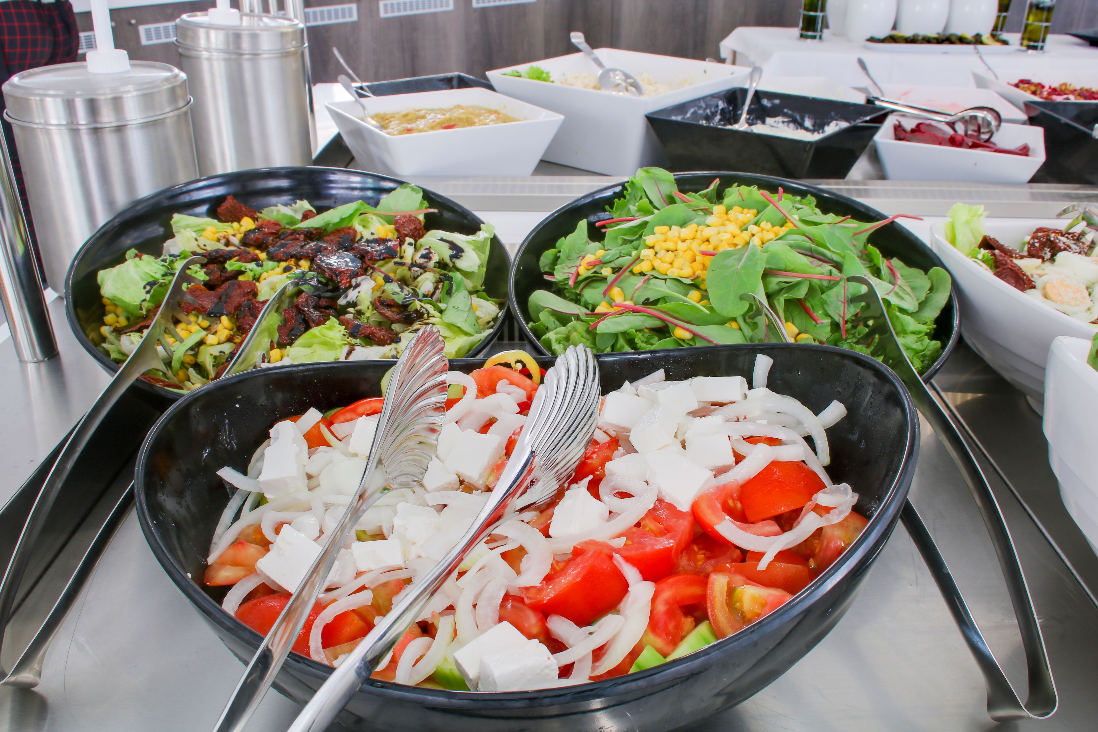 Buffet com diversas saladas e opções de comida.