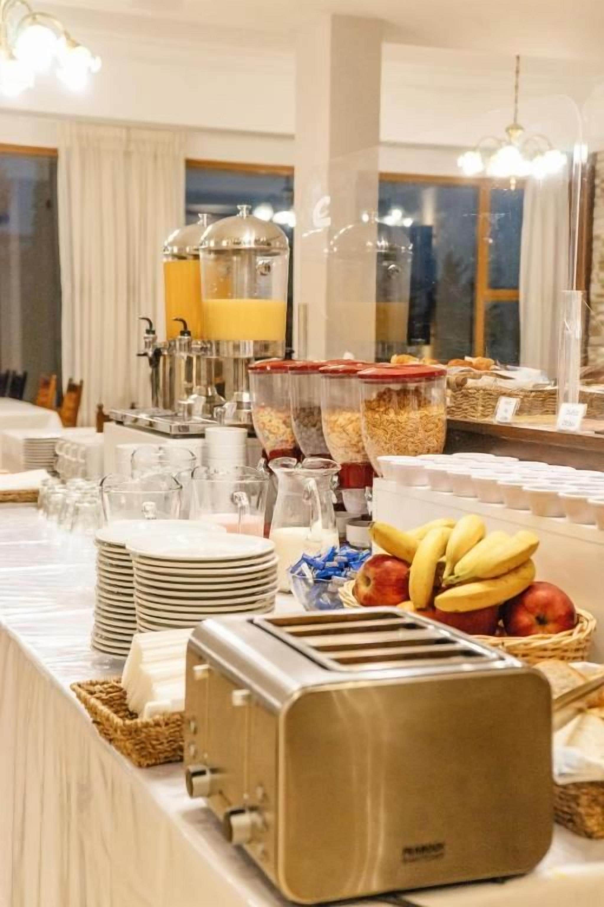 Um buffet de café da manhã com diversas opções de alimentos, uma torradeira e um espaço para café.