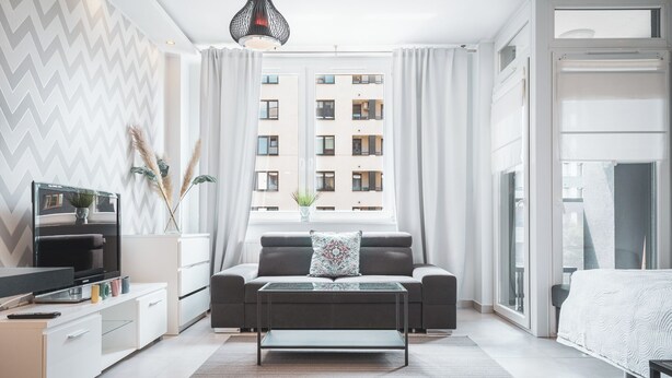 Uma sala de estar moderna com sofá, mesa de centro e televisão.