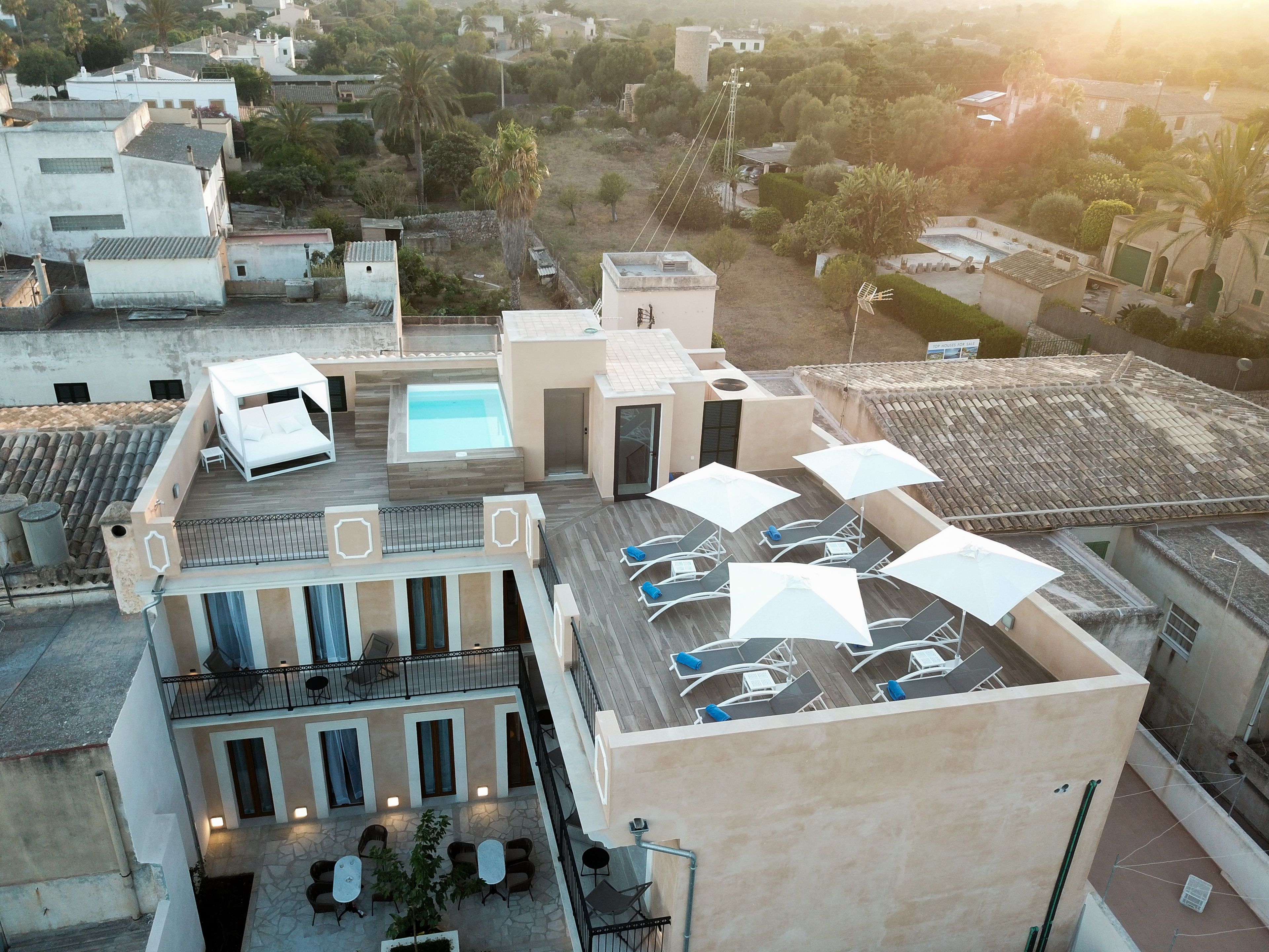 Terraço no telhado com piscina, espreguiçadeiras e guarda-sóis.
