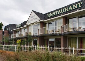 Hotel com restaurante no andar superior, com varandas equipadas com mobiliário de exterior.
