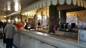 Uma área de buffet com balcão, alimentos e máquina de café.