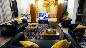 Uma sala de estar moderna com um mapa-múndi na parede, uma TV de tela plana e assentos confortáveis.