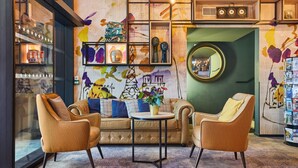 Um interior moderno com um sofá, duas poltronas, uma mesa redonda e uma estante de livros.