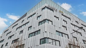 Um edifício moderno com fachada geométrica singular, exibindo um letreiro 'Odalys CITY' bem visível no topo.