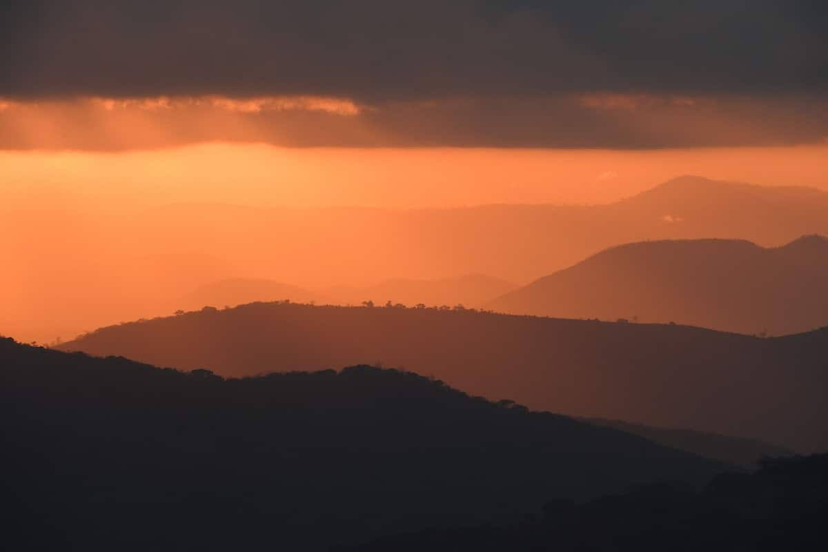 Paisagem montanhosa ao pôr do sol, com céu limpo.