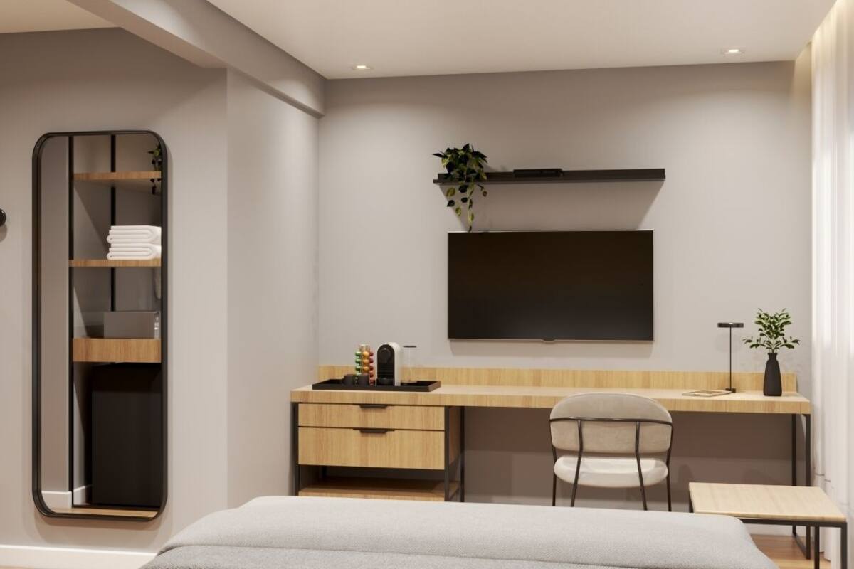 Quarto moderno com cama, escrivaninha, cadeira, televisão, espelho e guarda-roupa.