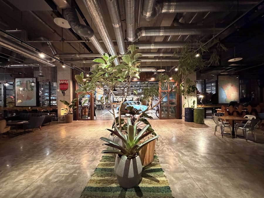 Um espaço interior com uma planta central, áreas de estar e uma porta de saída visível.