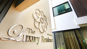 Um edifício com uma placa que diz 'The Luxury Residence'.