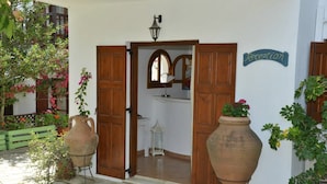 Uma área de recepção com portas de madeira abertas, um espelho, uma luminária e uma placa com a inscrição 'Reception'.