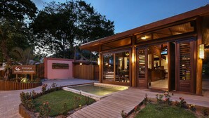 Uma casa moderna com deck de madeira, piscina e jardim.
