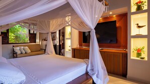 Quarto com cama de dossel, cómoda de madeira, televisão e prateleiras decorativas com flores.