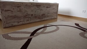 Quarto com uma grande cômoda de madeira rústica em frente a uma parede branca.