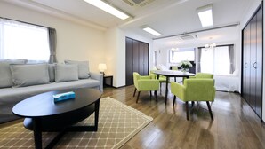 Uma sala de estar moderna com sofá, mesa de centro e poltronas verde-claras.