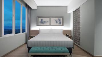 Quarto moderno com uma janela grande, uma cama com um banco estofado cor turquesa e duas obras de arte emolduradas na parede.