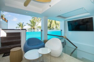 Um interior moderno com vista para a piscina, uma escadaria e uma televisão de tela plana.
