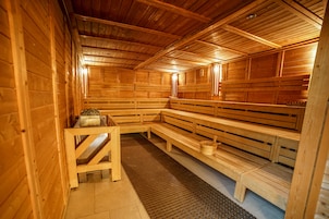 Uma sauna de madeira com bancos e um banco com um balde.