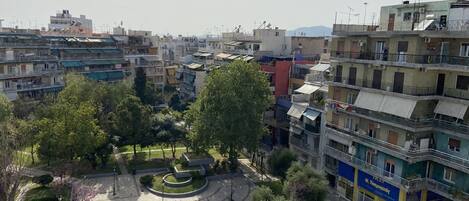 Edifício residencial com várias andares, varandas, uma praça circular central e áreas verdes ao redor.