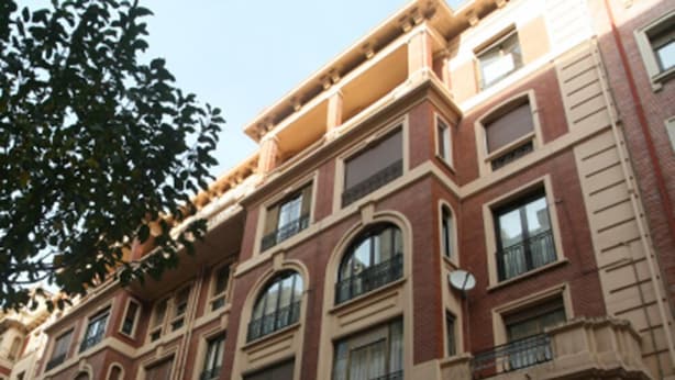 Um hotel de vários andares com estilo arquitetônico clássico, com janelas em arco e varandas.
