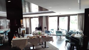 Uma sala de jantar moderna com mesa de buffet, cadeiras e vista para o exterior.
