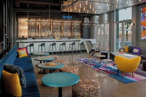 Espaço lounge moderno com bar, assentos e vista da cidade.