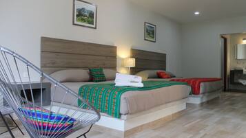 Quarto com cama, uma cadeira e banheiro visível por uma porta aberta.