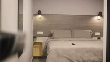 Quarto moderno com uma cama grande, duas mesas de cabeceira com abajures e um pequeno armário de madeira.