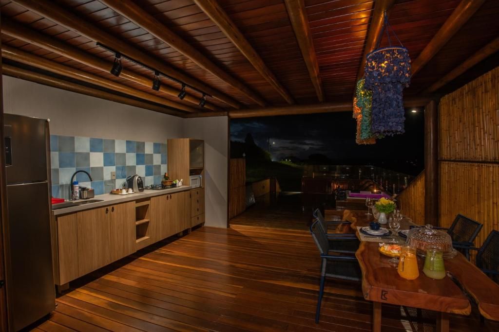 Cozinha moderna com armários de madeira, geladeira de aço inoxidável e painel de fundo xadrez.