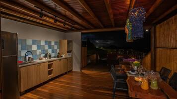 Cozinha moderna com armários de madeira, geladeira de aço inoxidável e painel de fundo xadrez.