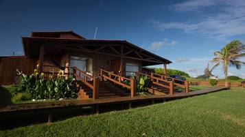 Uma casa moderna com um deck de madeira, uma escadaria e uma garagem.