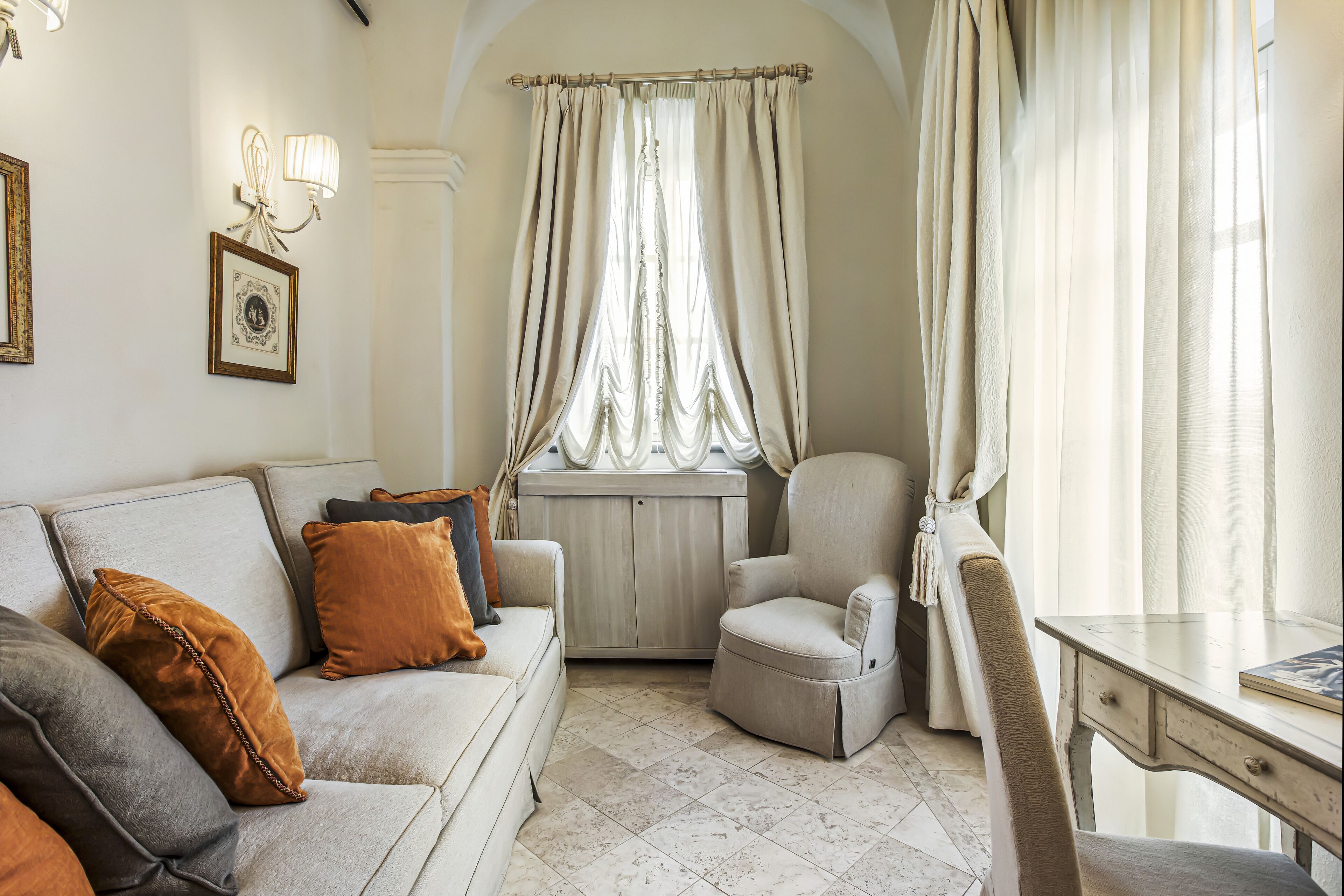 Uma sala de estar com sofá, poltrona e mesa.