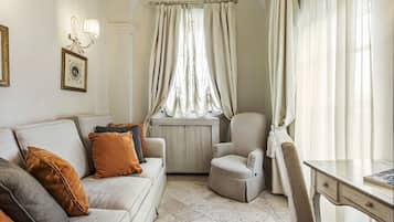 Uma sala de estar com sofá, poltrona e mesa.